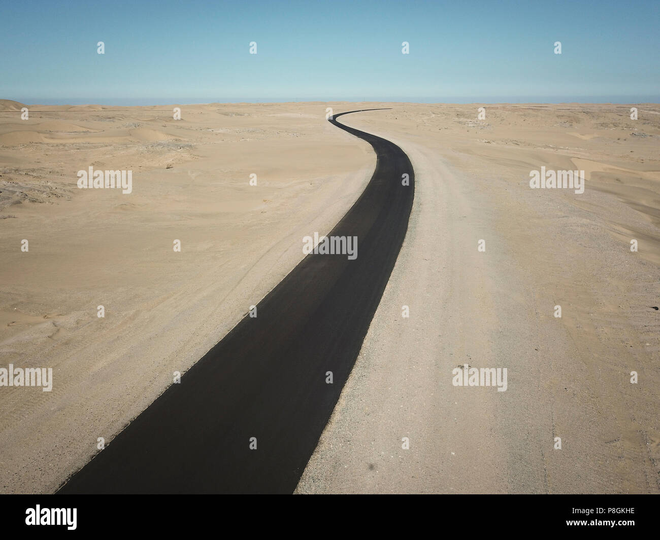 Long straight tar road running through a very dry desert in Namibia ...