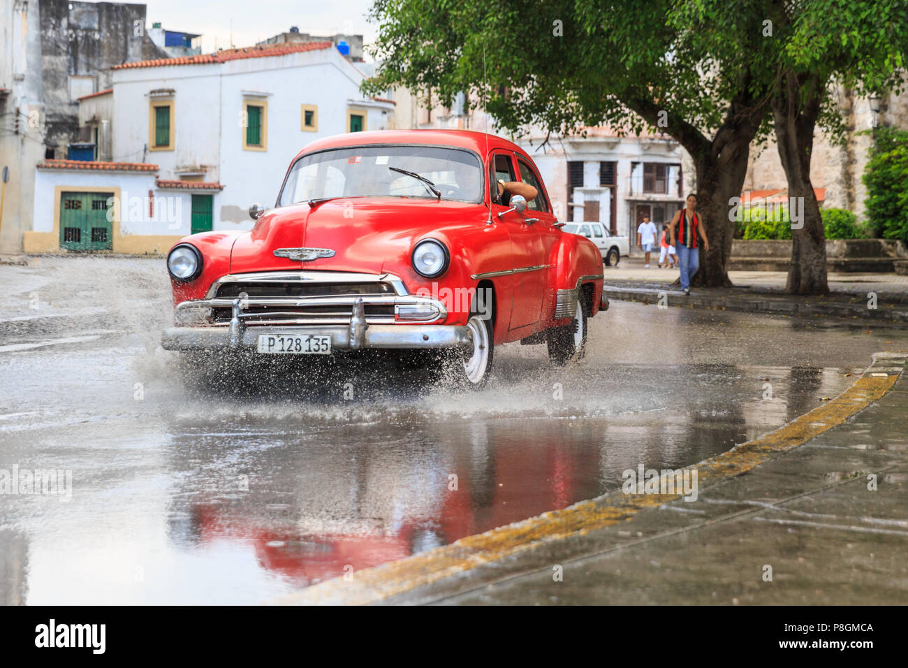 Red Chevrolet American classic car, vintage car splashing in the rain ...