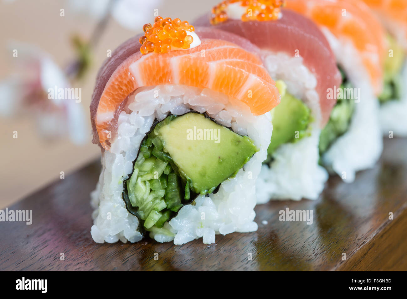 Fresh sushi roll with rice, salmon, avocado and fish roe Stock Photo ...