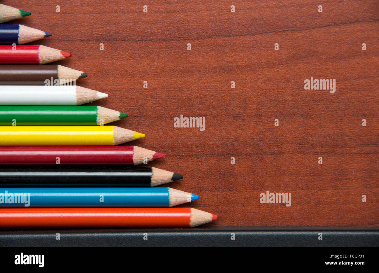Colorful Pencils Stacked Up On A Wooden Desk Stock Photo - Alamy