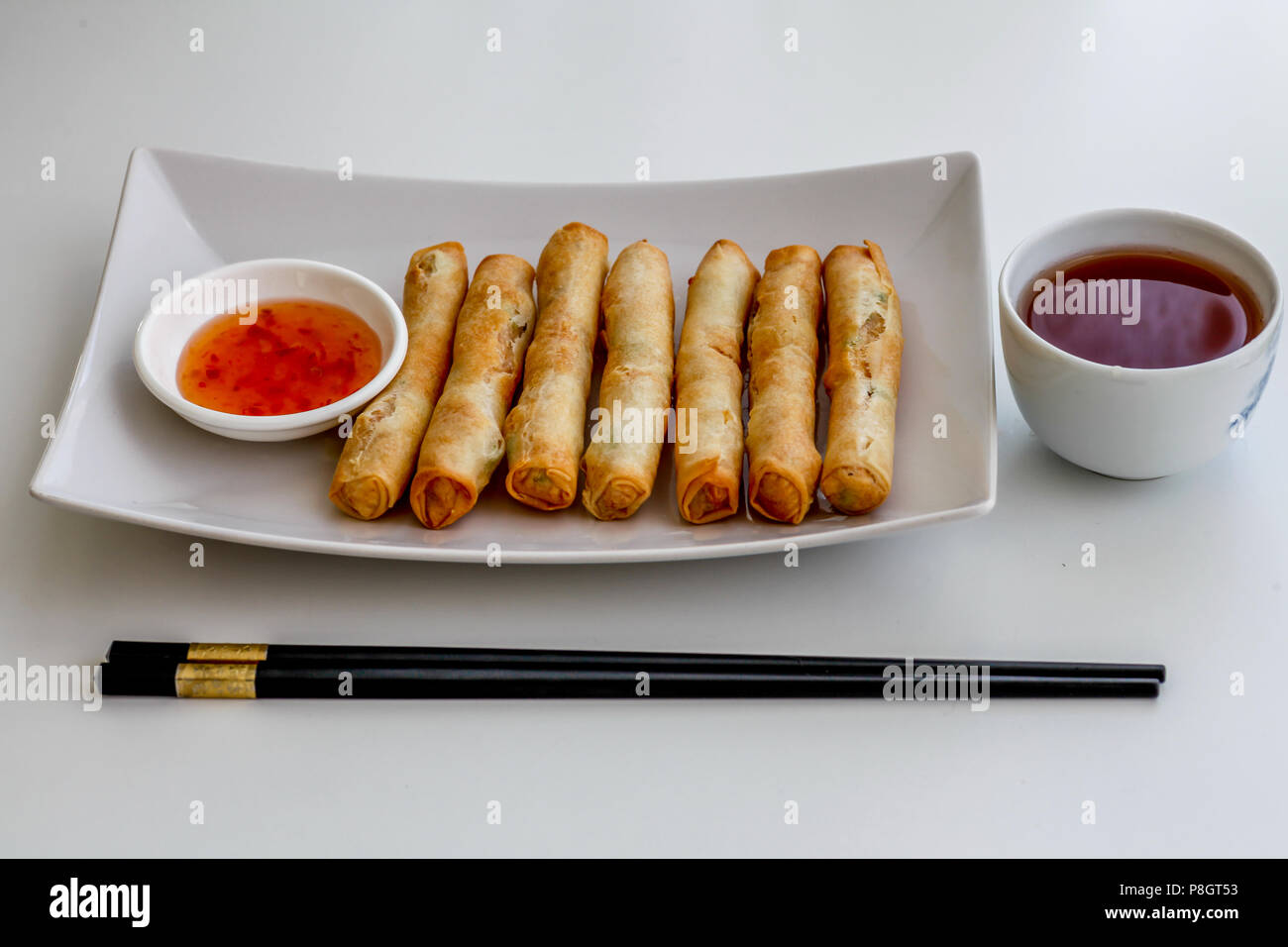 Spring Rolls served with dipping sauce and a cup of Chinese tea Stock ...
