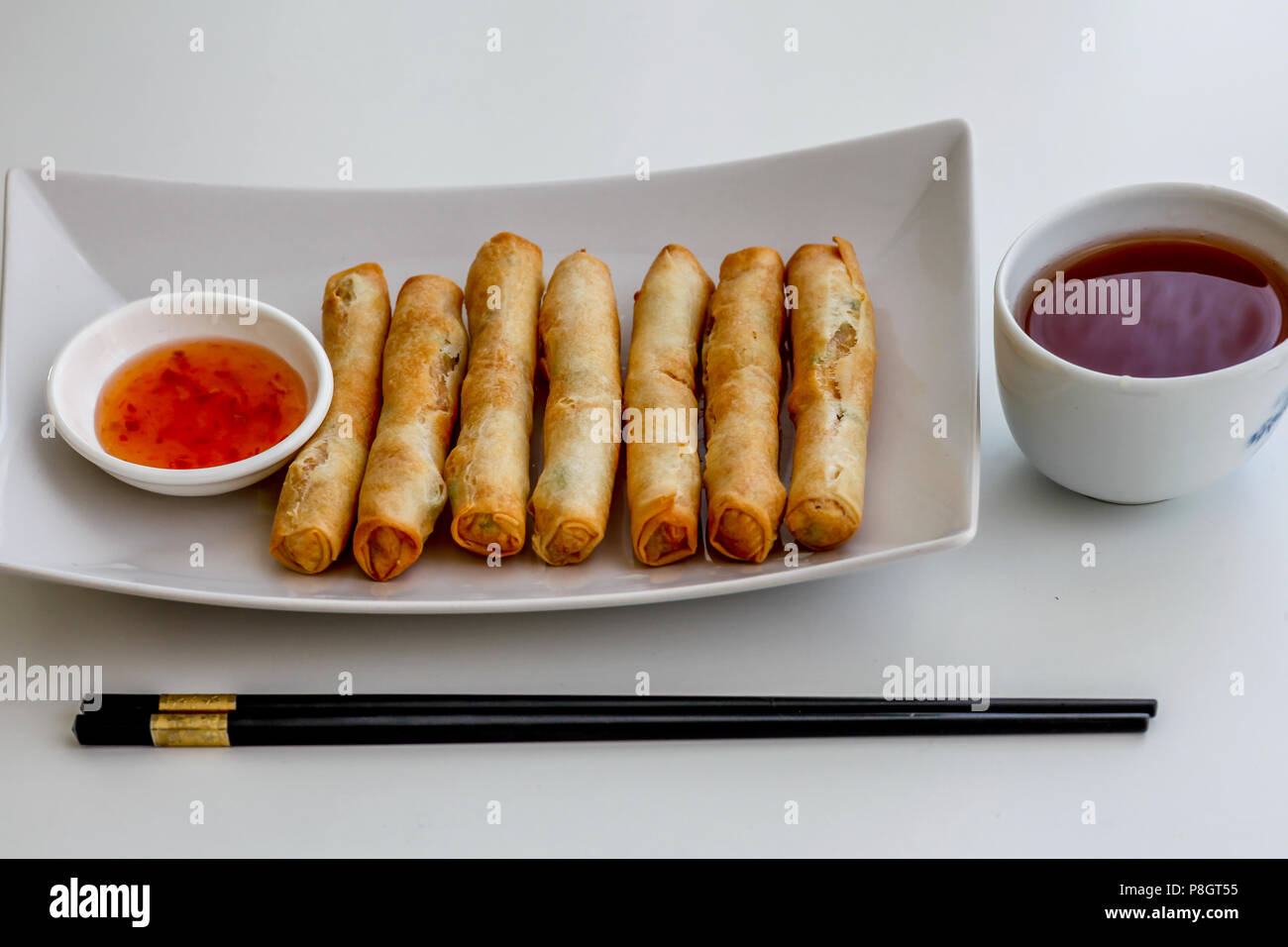 Spring Rolls served with dipping sauce and a cup of Chinese tea Stock ...