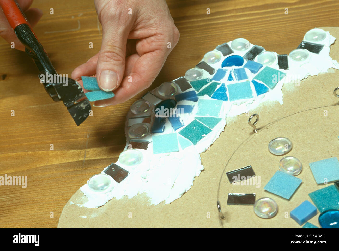 Close-up of hands applying glue to mosaic on MDF ceiling rose FOR ...