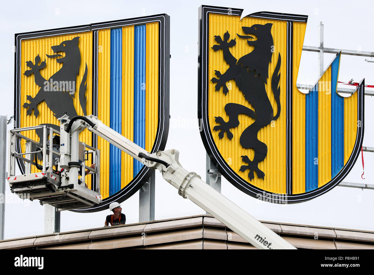 Leipzig, Germany. 11th July, 2018. Technicians attach a neon sign with ...