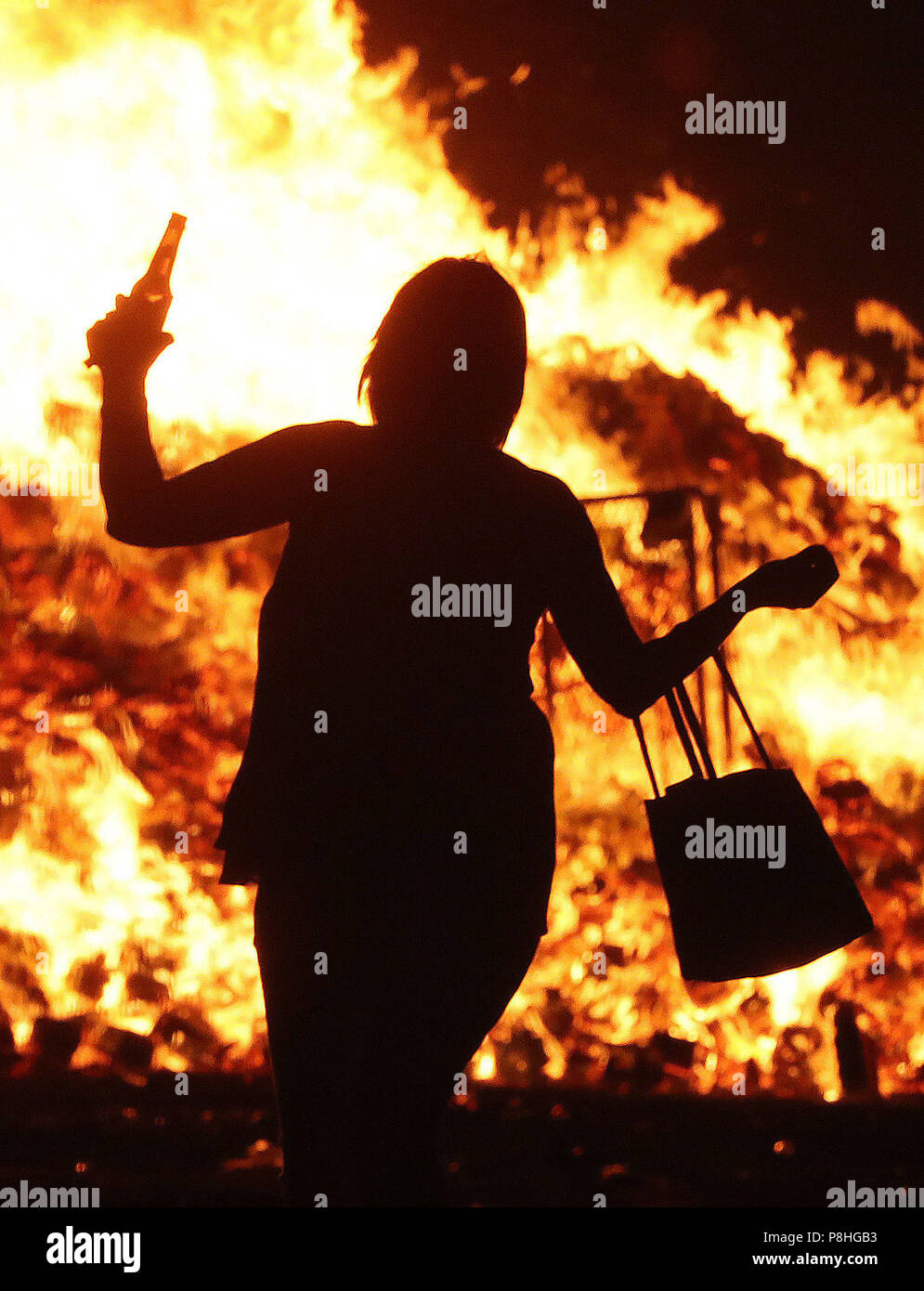 People attend an 11th night Bonfire in the Sandy Row area of Belfast ...