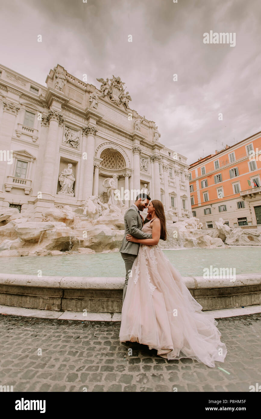 Just married bride and groom posing in front of Trevi Fountain (Fontana ...