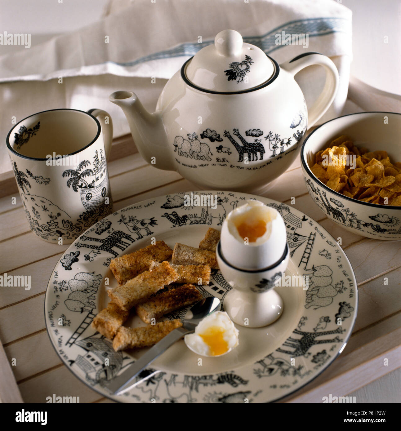 Breakfast tray with a boiled egg and toast soldiers and a teapot with a ...