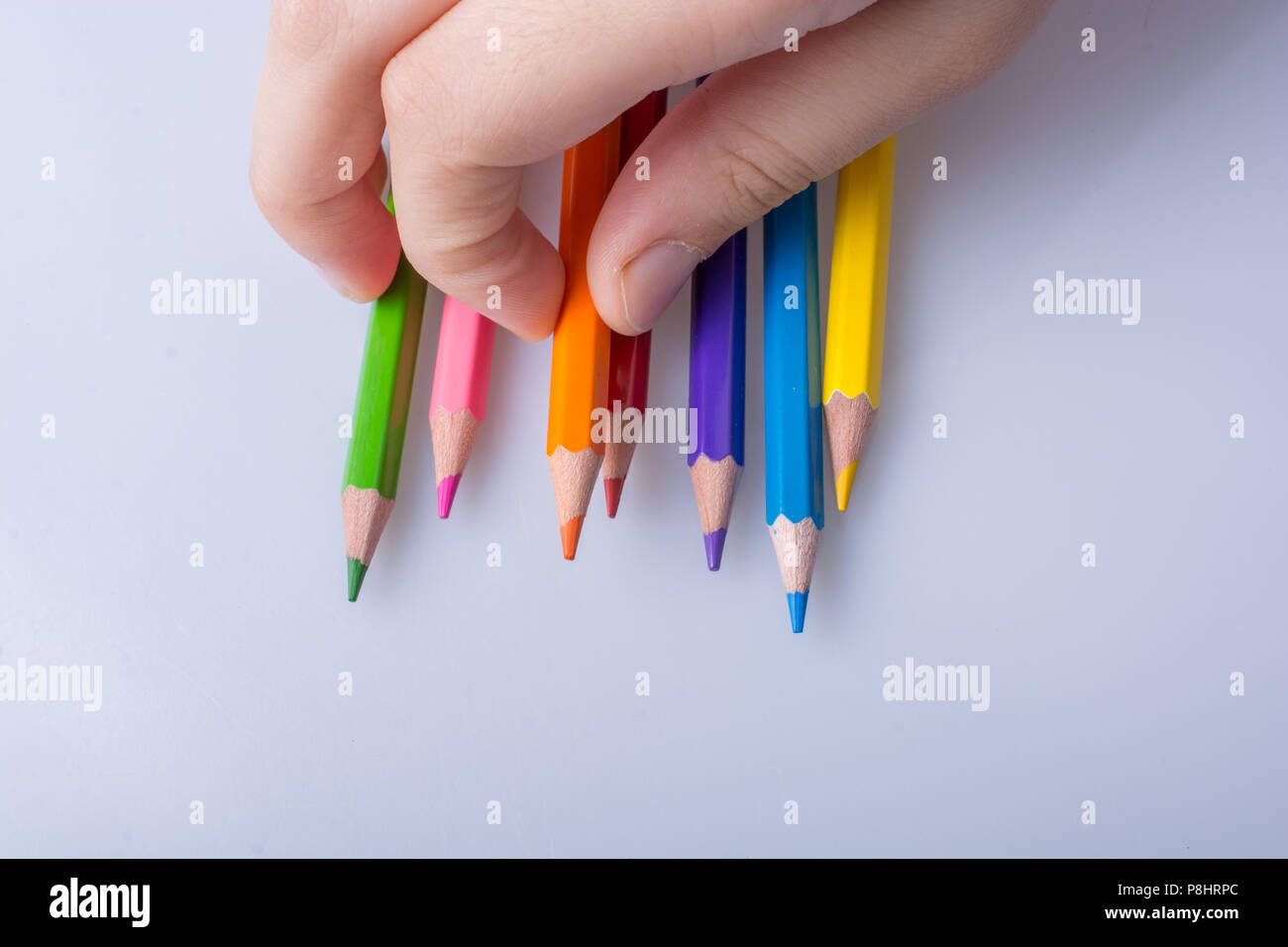 Hand holding color Pencils placed on a white background Stock Photo - Alamy