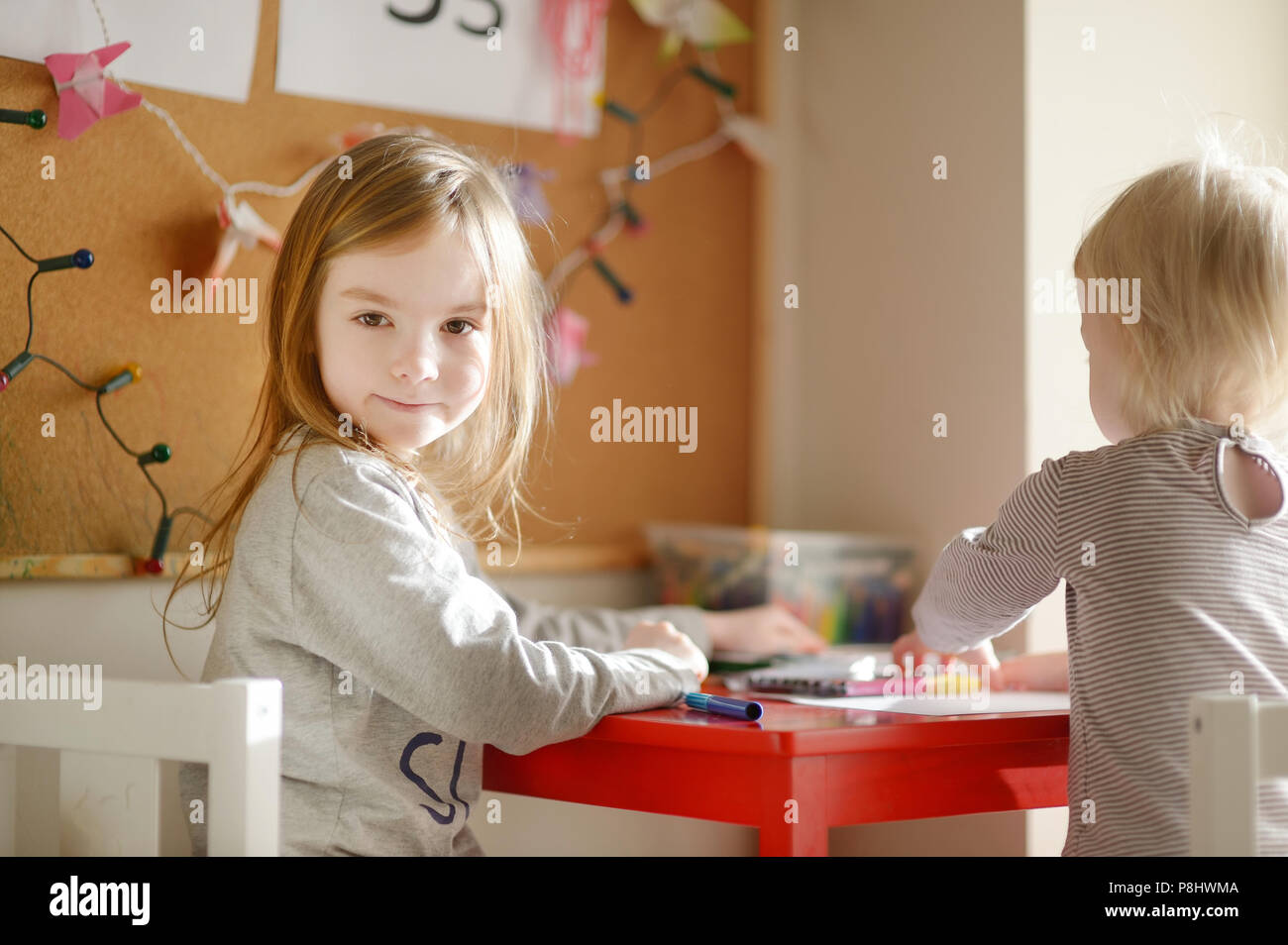 Cute little girl is drawing with pencils in preschool Stock Photo - Alamy