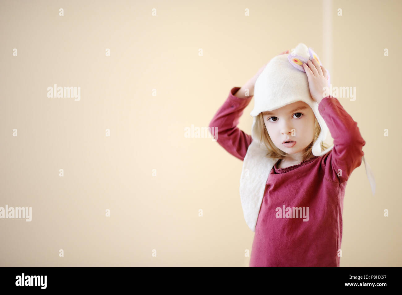 Adorable little girl wearing funny white hat Stock Photo - Alamy