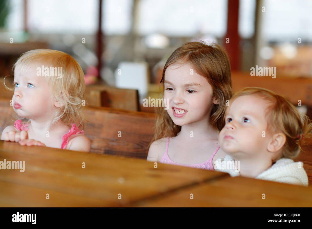 Three little kids in an outdoor restaurant Stock Photo - Alamy