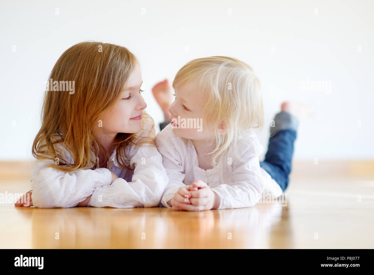 Portrait of two cute sisters at home Stock Photo - Alamy
