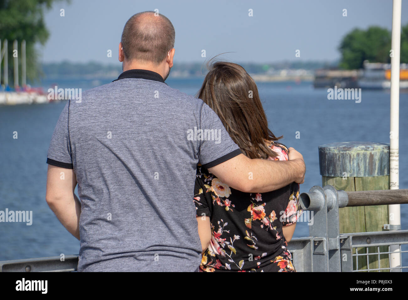 Couple looking out over water Stock Photo - Alamy