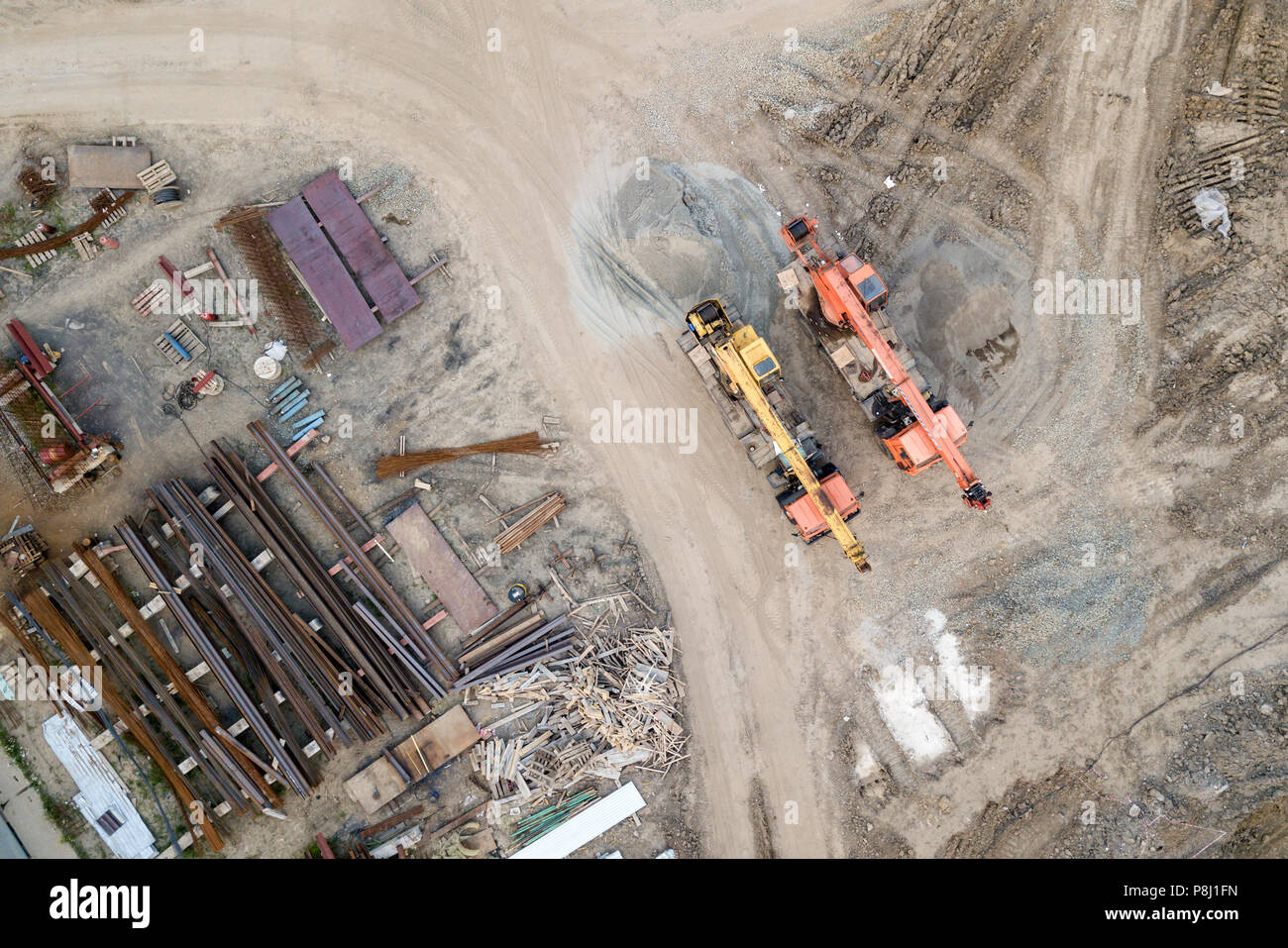 Aerial top view: constraction crane or trucks go together country road ...