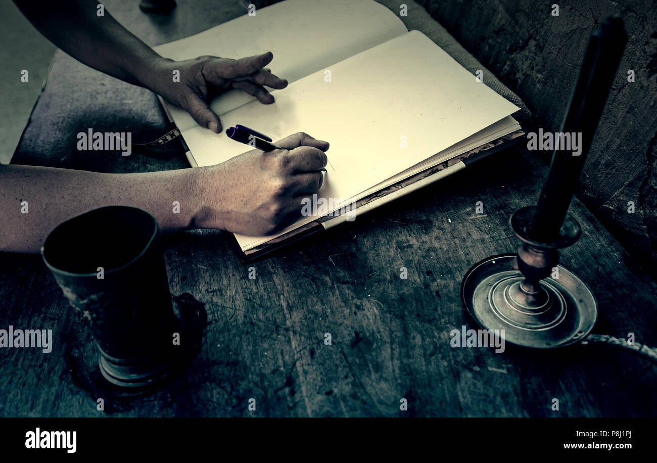 Old medieval desk with pen and book, detail of place to read and write ...