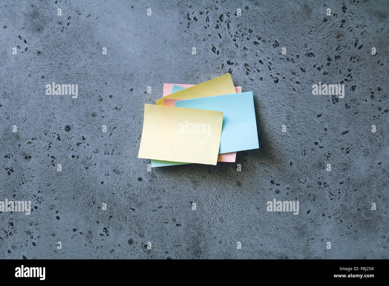 Colorful empty sticky notes on a grey textured background. The concept ...