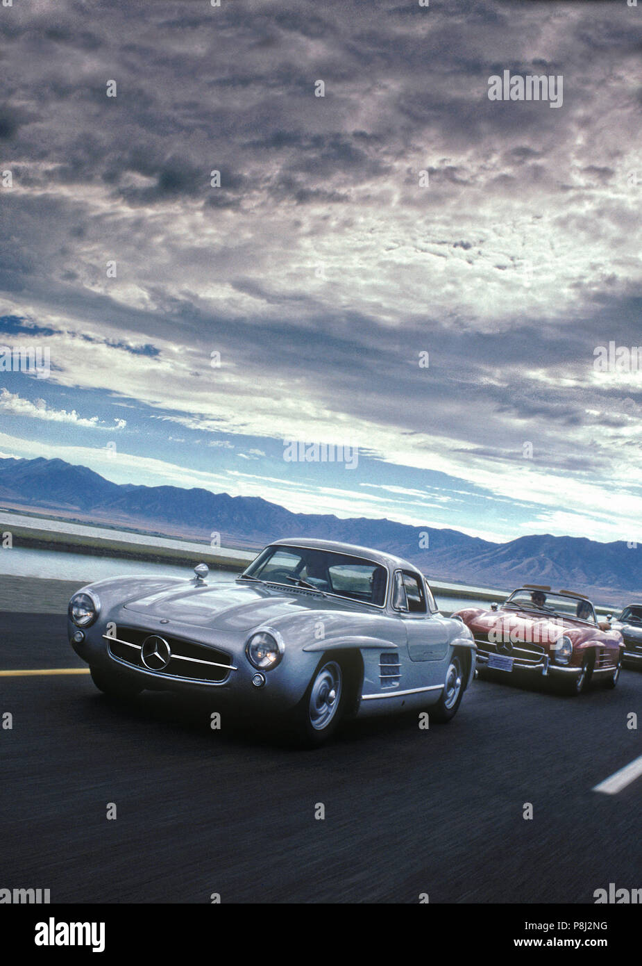Mercedes Benz 300SL Gullwing and Roadster cars driving along the shore ...