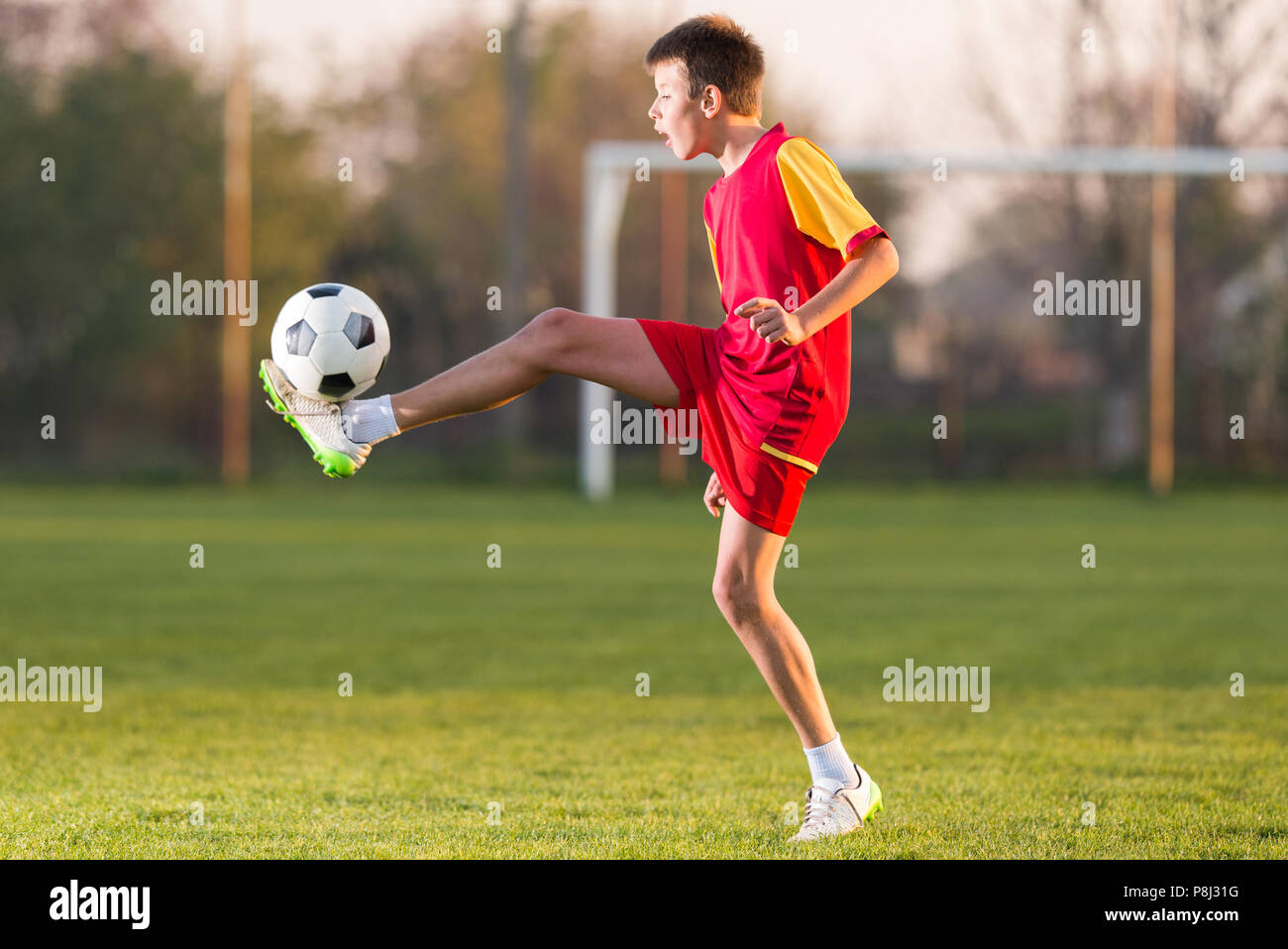 Child playing football on a soccer field Stock Photo - Alamy
