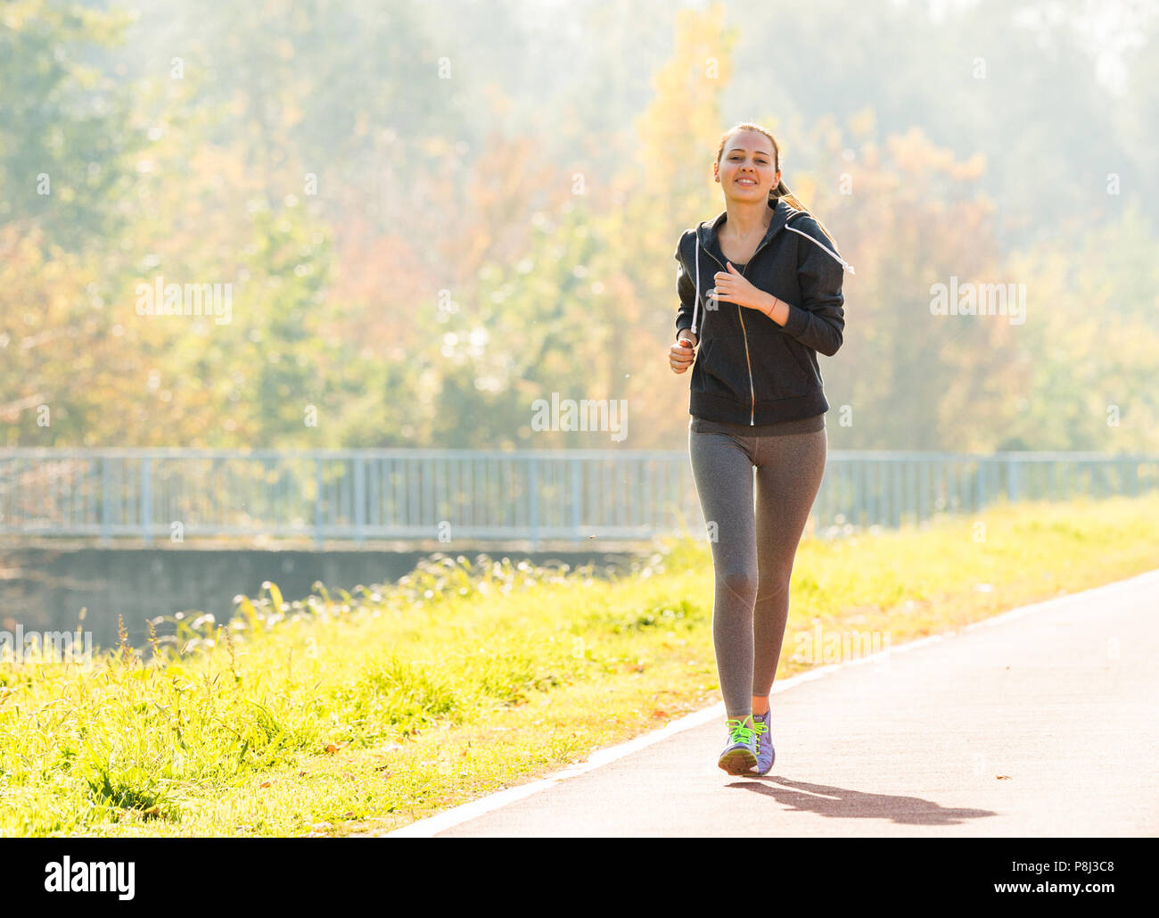 Pretty young girl jogging in the park Stock Photo - Alamy
