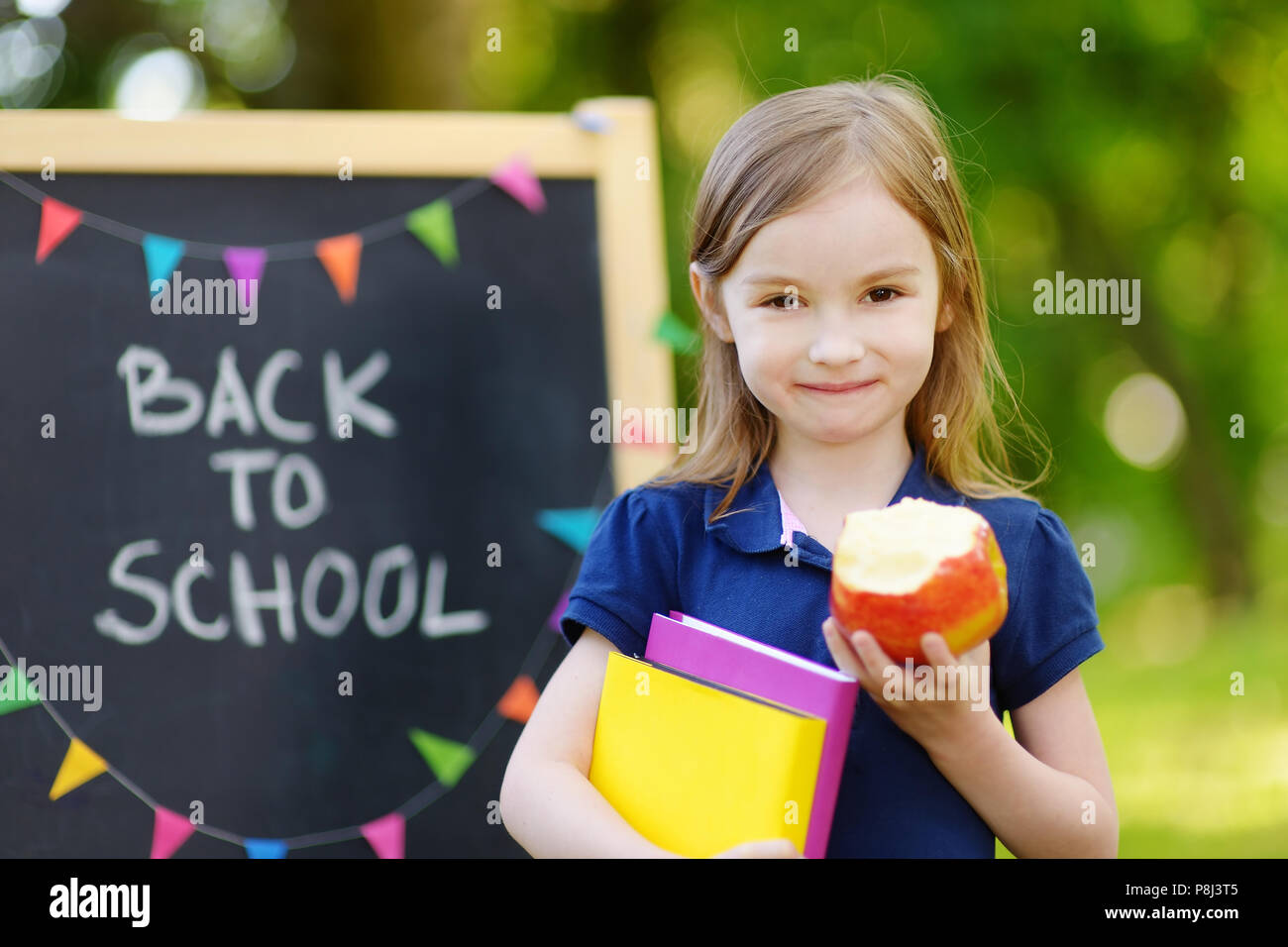 Adorable little schoolgirl feeling extremely excited about going back ...