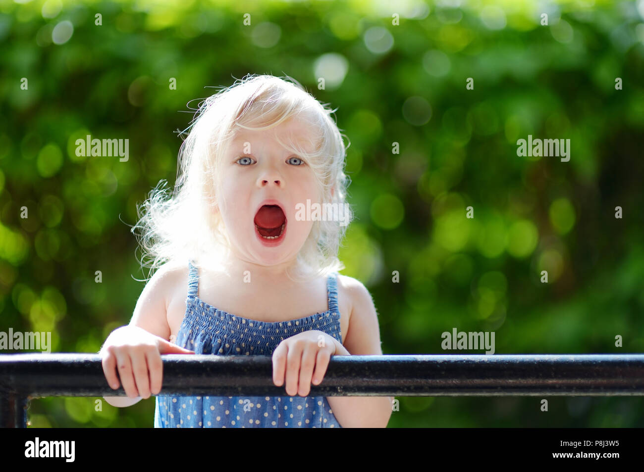 Adorable toddler girl screaming, singing and making funny faces ...