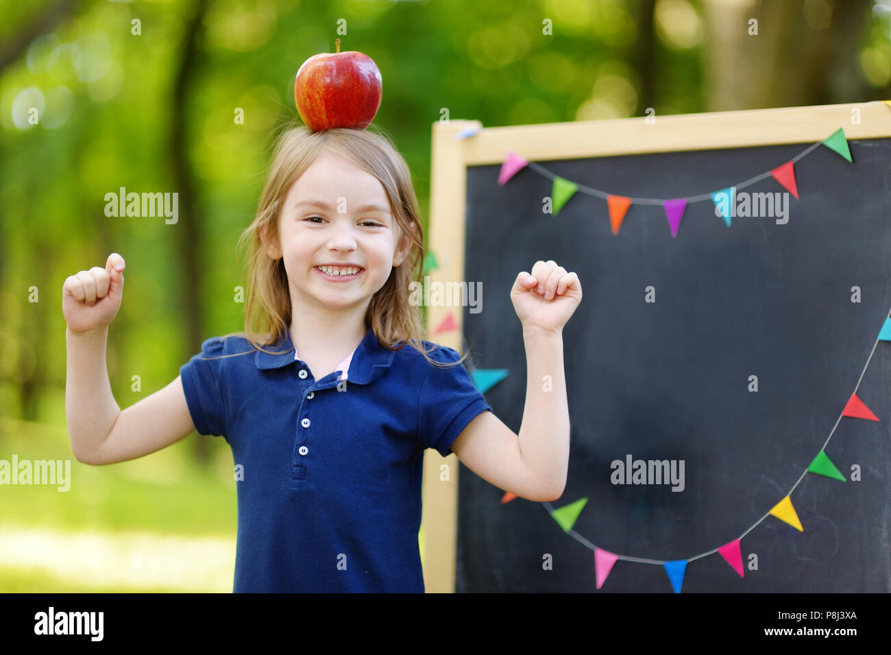 Adorable little schoolgirl feeling extremely excited about going back ...