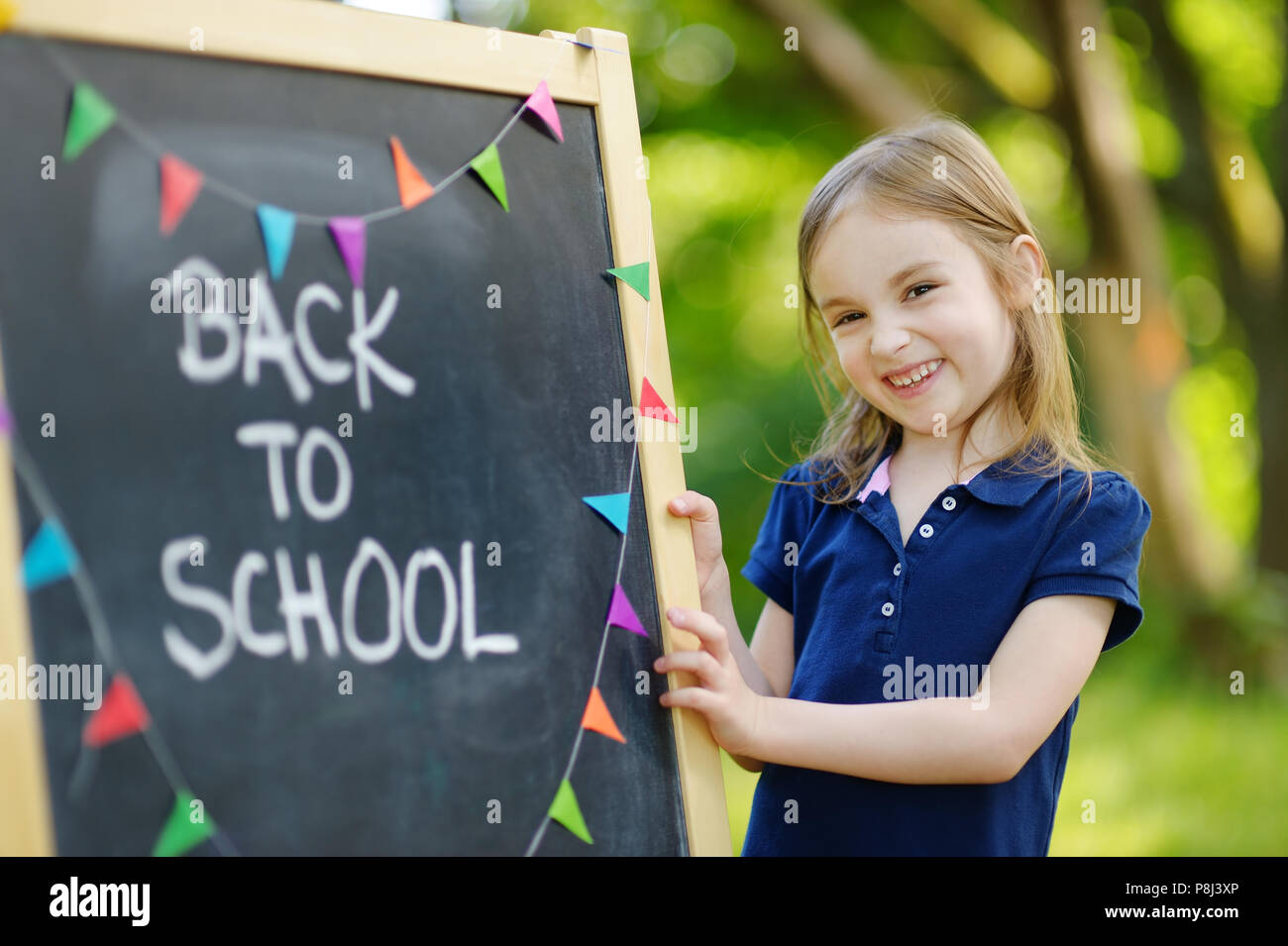 Adorable little schoolgirl feeling extremely excited about going back ...