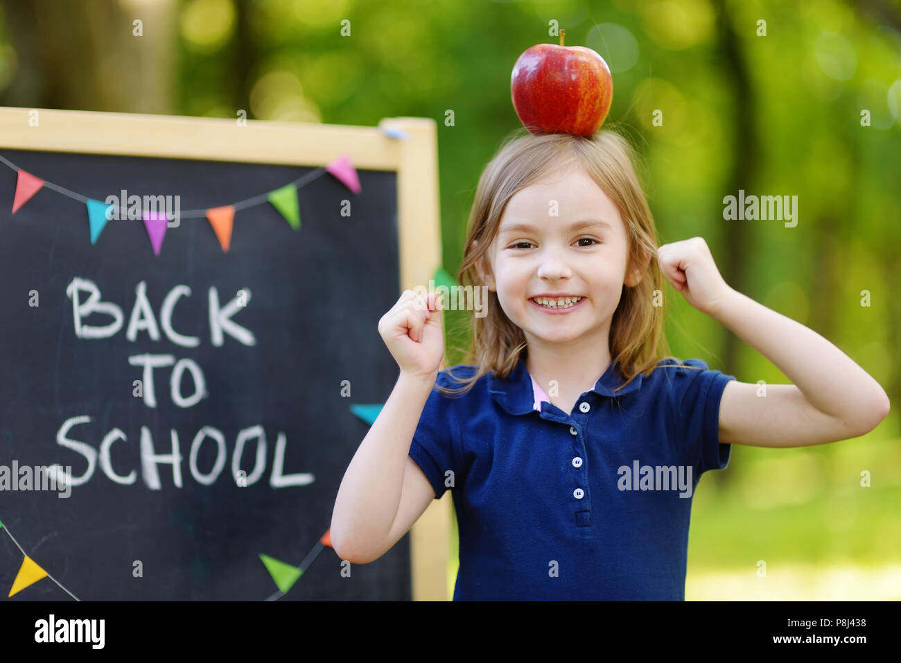 Adorable little schoolgirl feeling extremely excited about going back ...