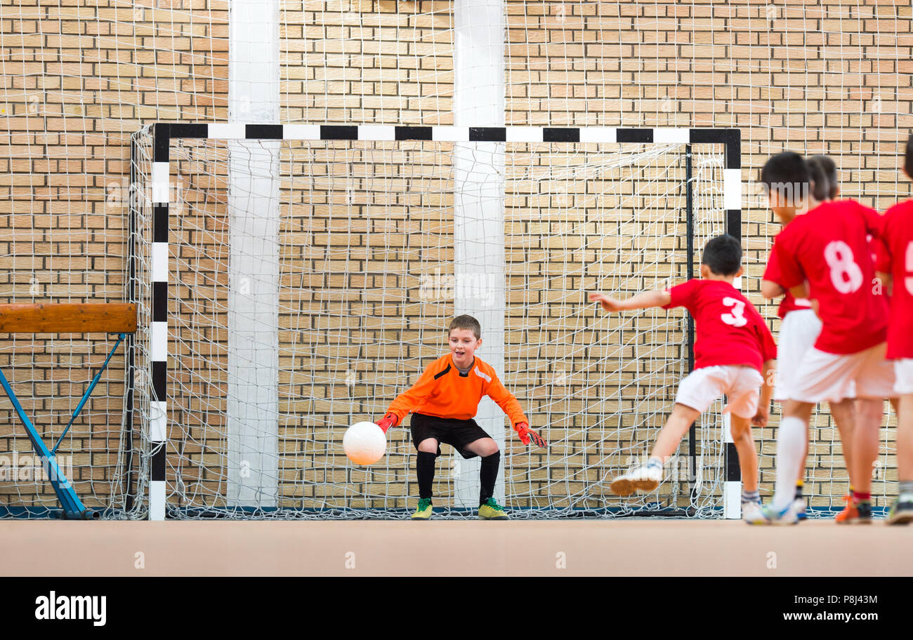 Boy kicking soccer ball at net hi-res stock photography and images - Alamy
