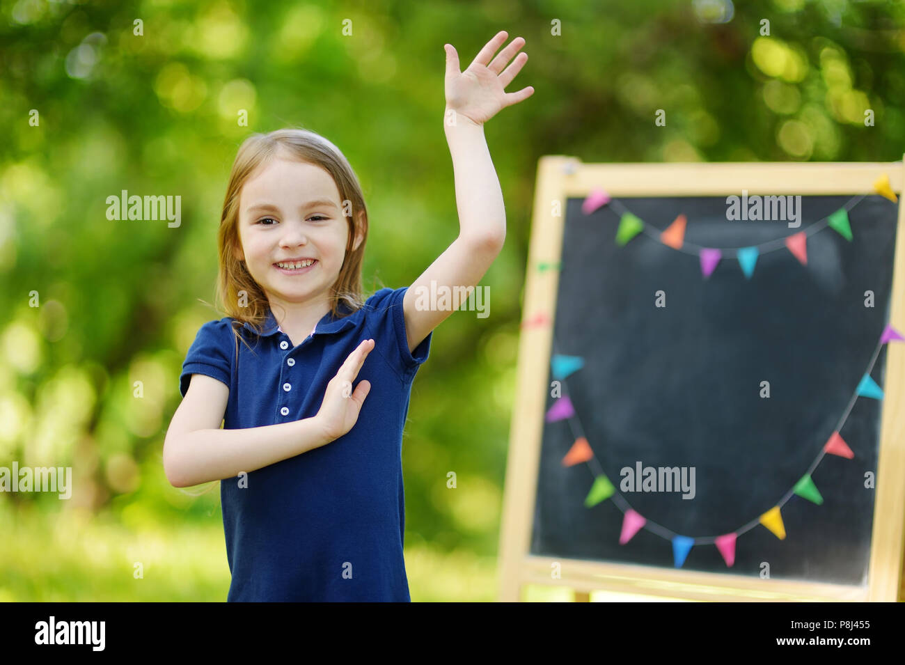 Adorable little schoolgirl feeling extremely excited about going back ...