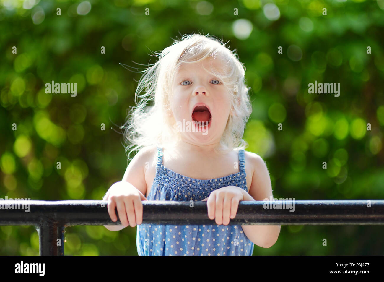 Adorable toddler girl screaming, singing and making funny faces ...