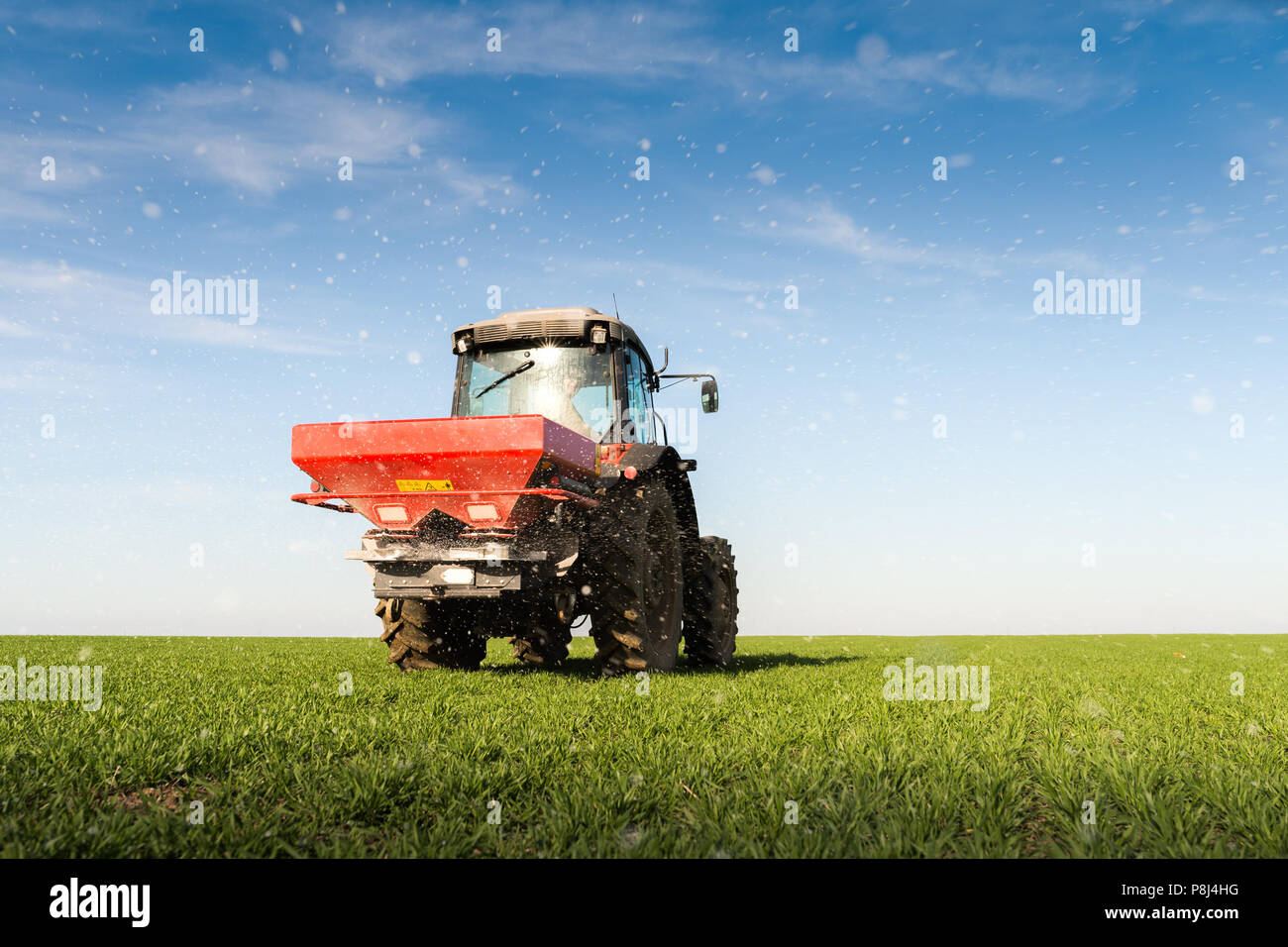 tractor fertilizing in wheat field Stock Photo - Alamy