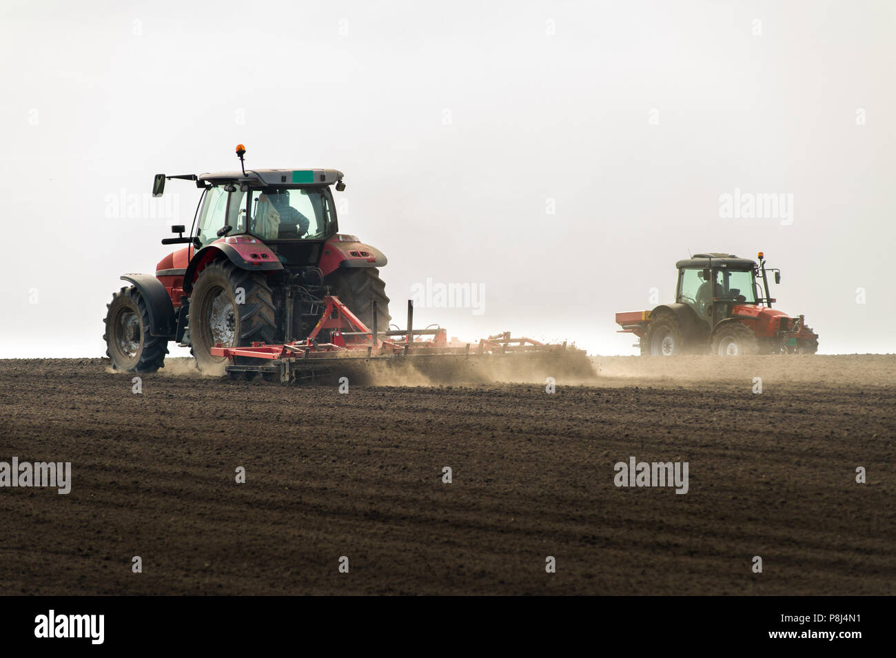 Tractors preparing land for sowing Stock Photo - Alamy