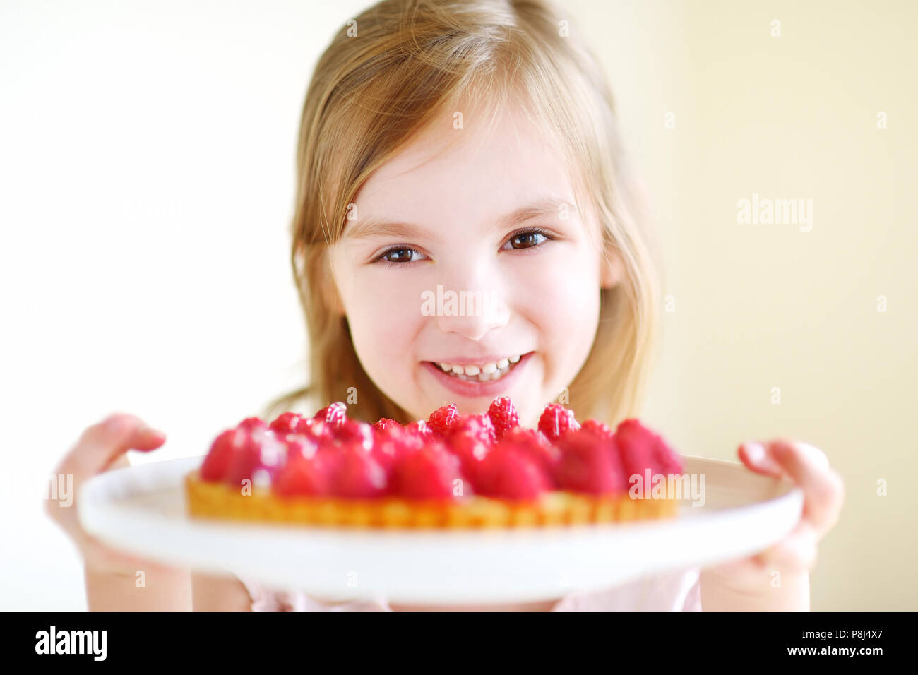 Adorable little girl and delicious raspberry cake Stock Photo - Alamy