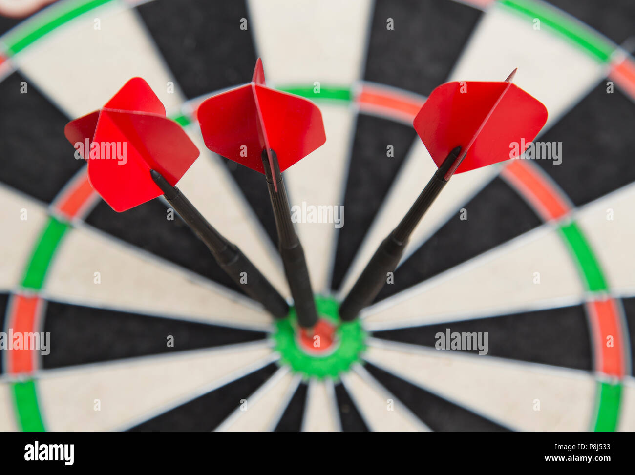 Three darts in a dartboard Stock Photo - Alamy