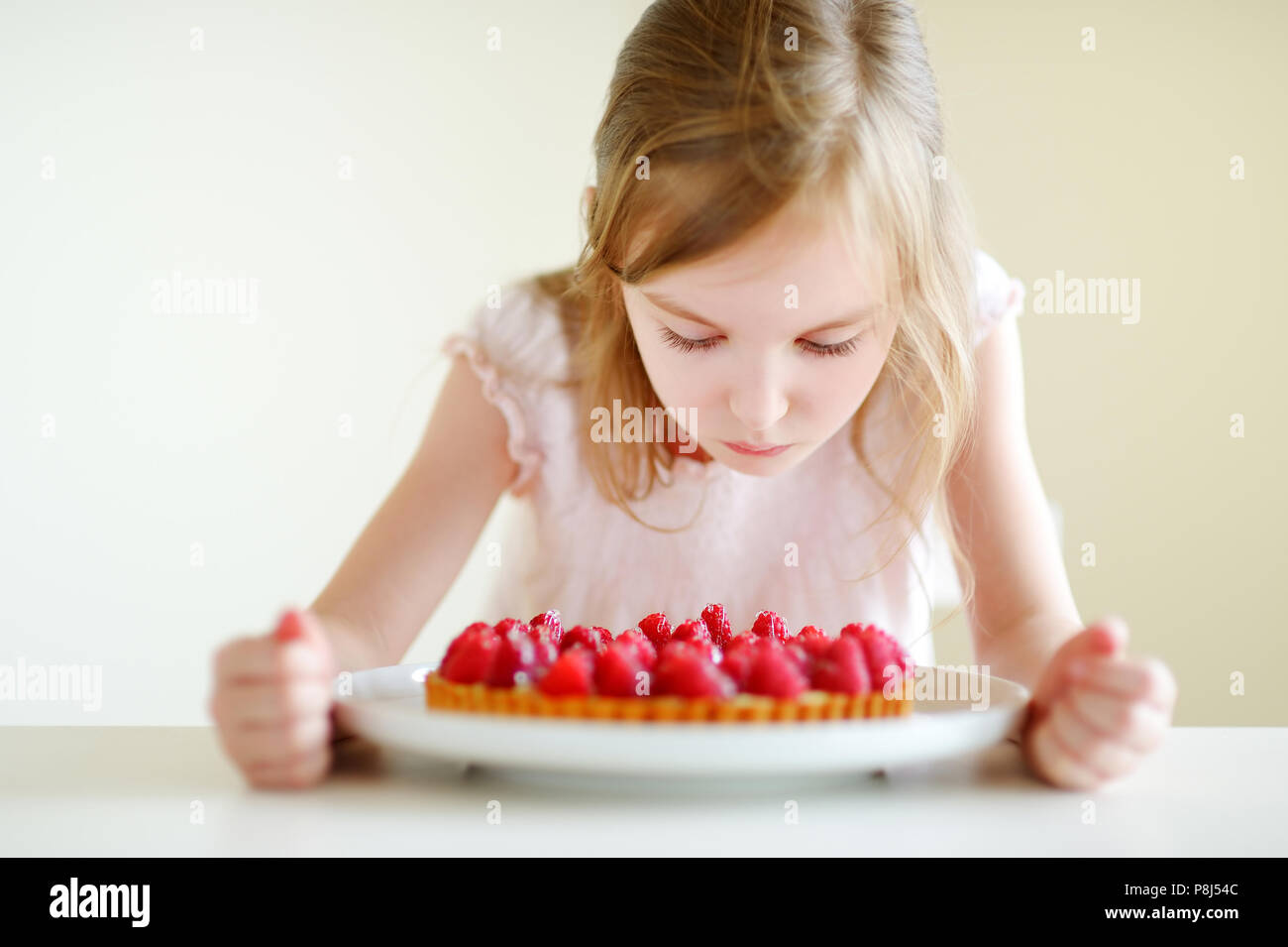 Adorable little girl and delicious raspberry cake Stock Photo - Alamy