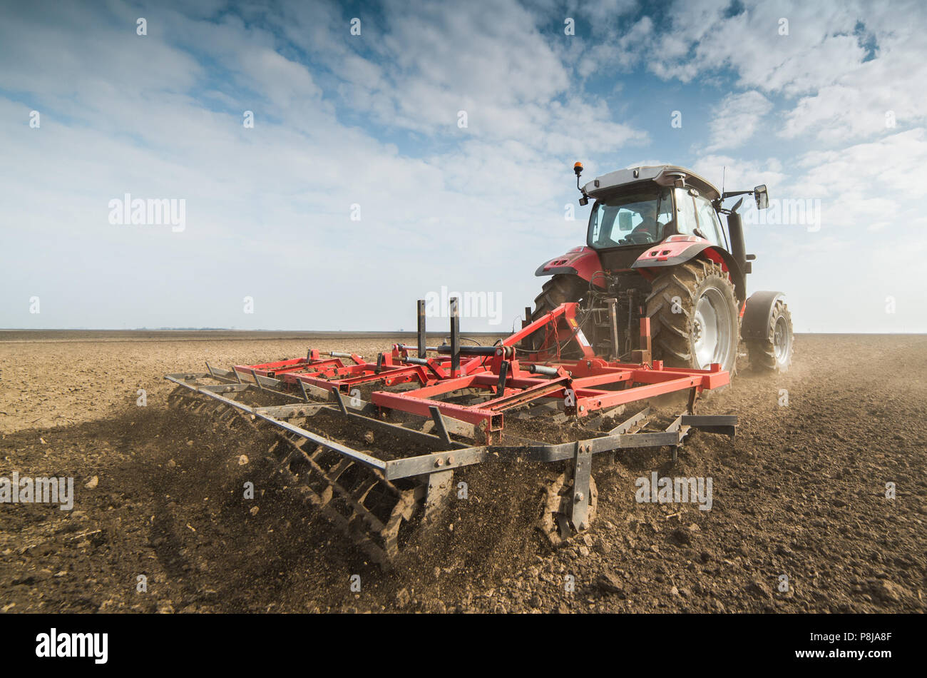 Tractor preparing land for sowing Stock Photo - Alamy