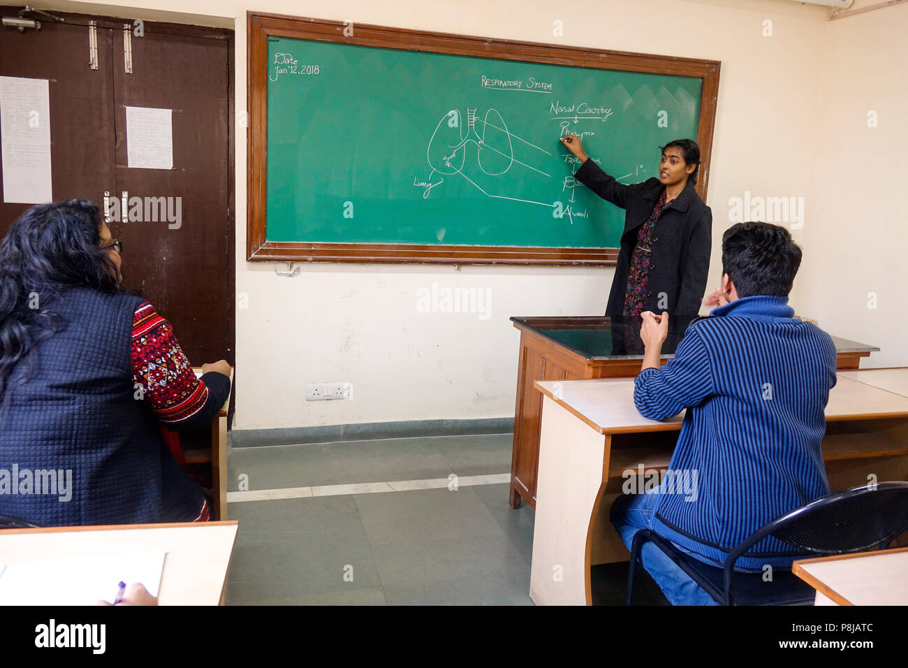 A young beautiful lady professor teaching and explaining science ...