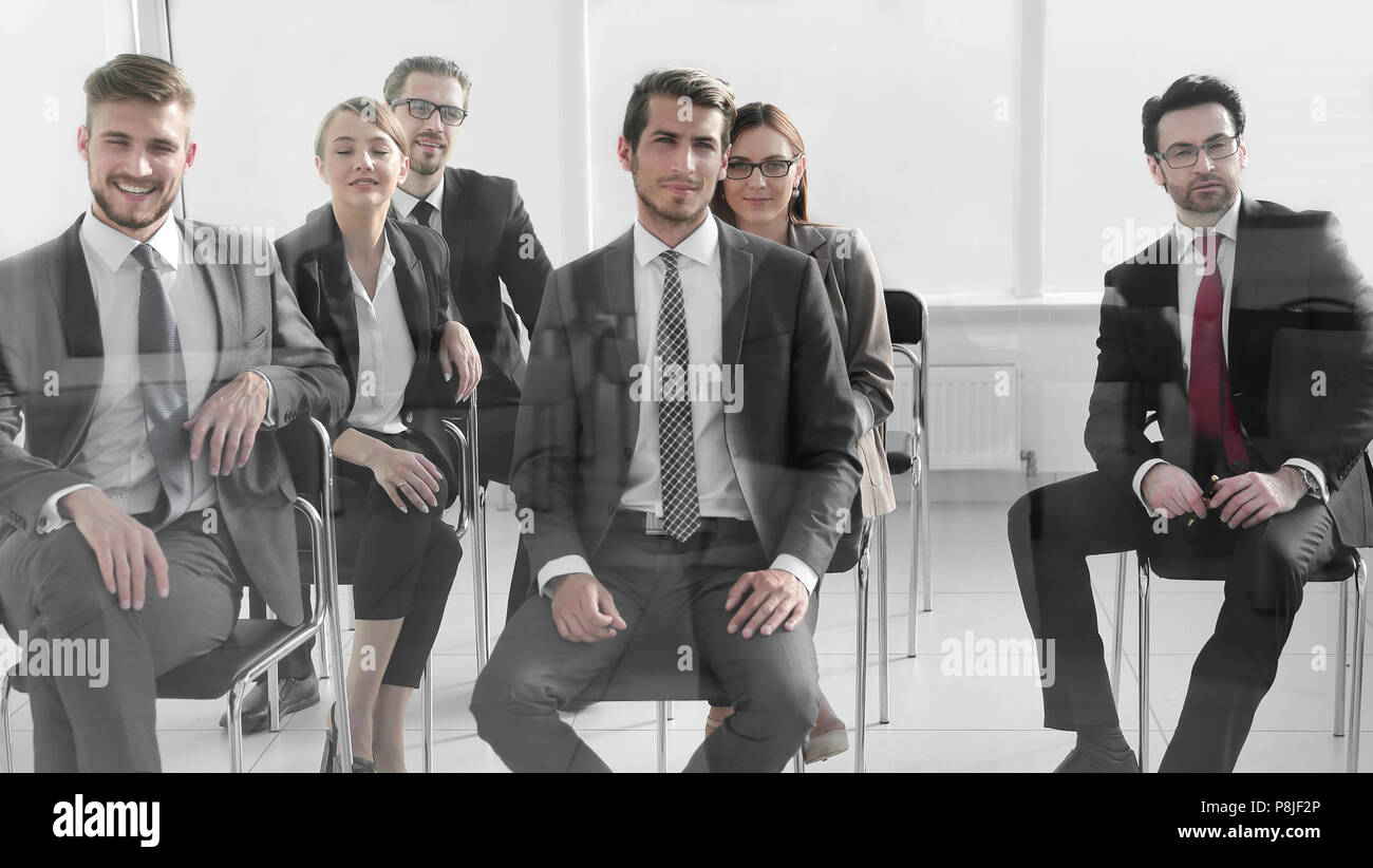 Man and women sitting on chairs in row Stock Photo - Alamy