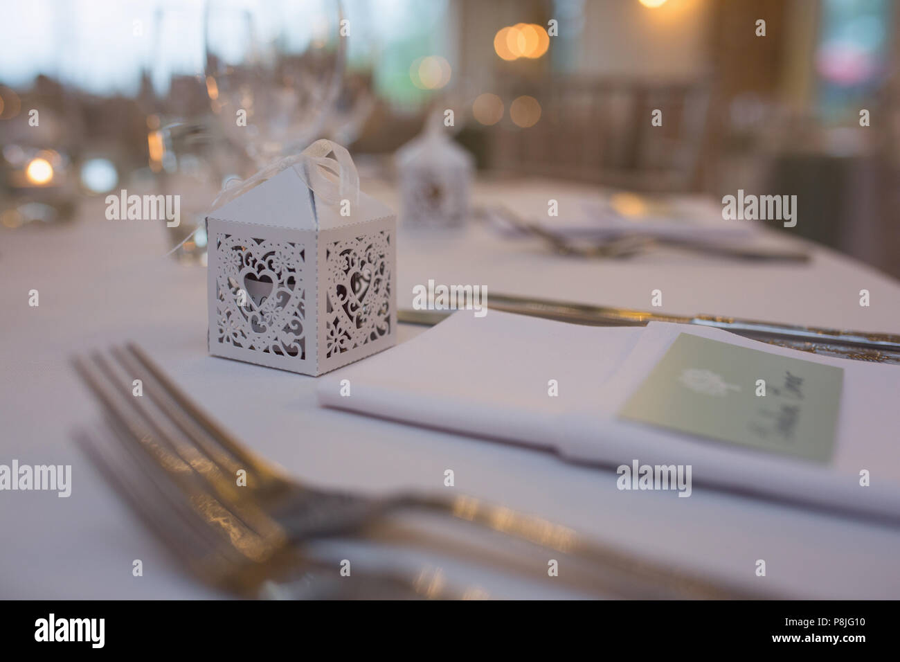 Wedding table favours at the venue. Candle box and place name Stock ...