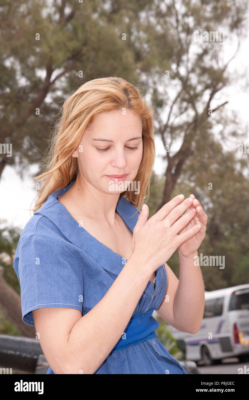 blonde lady stand and hold hands Stock Photo - Alamy