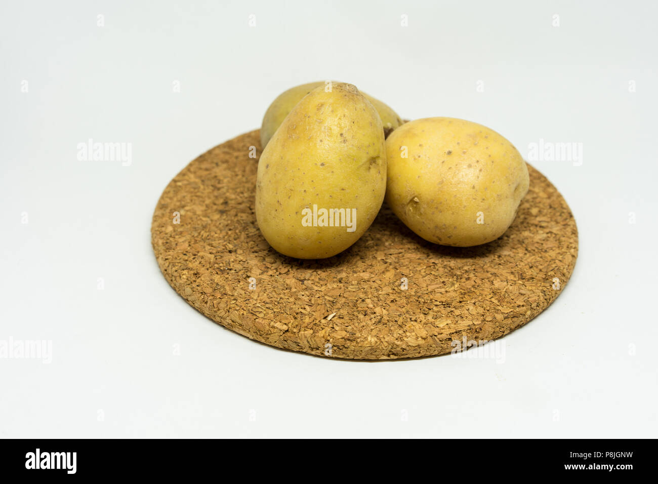 three patato isolated on cork with white background close up Stock ...