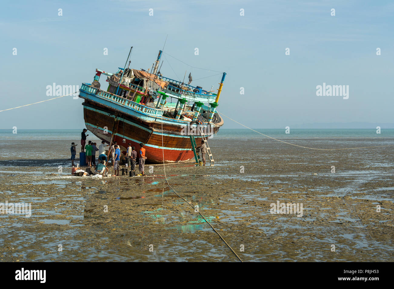 An old repurposed fishing boat is beached during low tide on a South ...