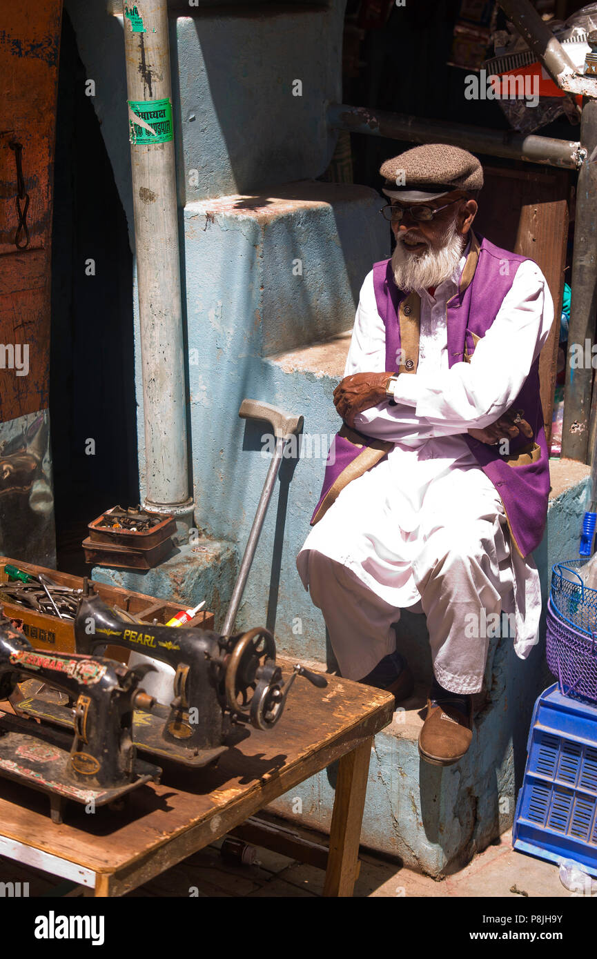 Old indian man selling old sewing machines on the street at Almora town ...