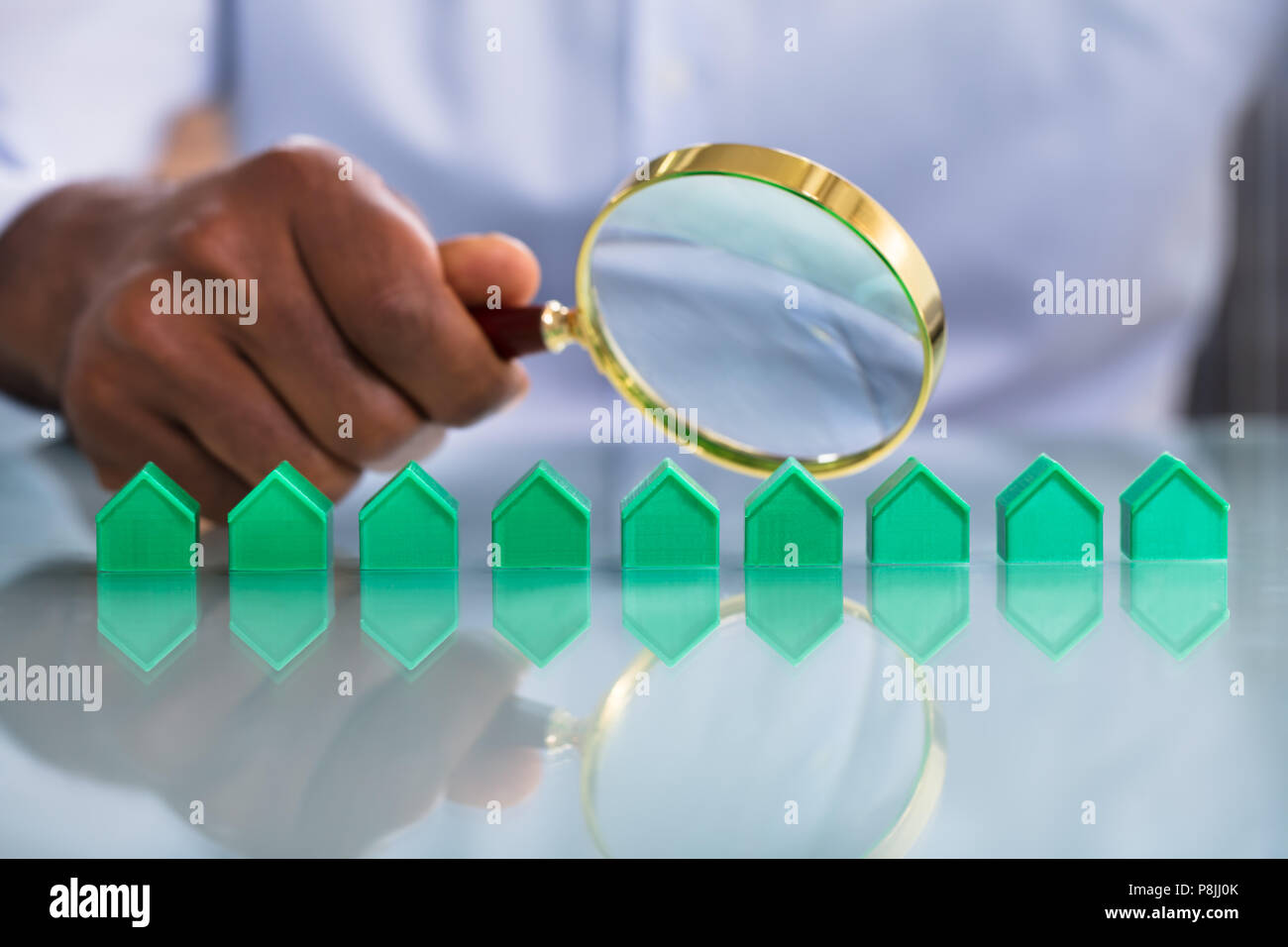 Businessman Looking Green Row Of Miniature Houses Through Magnifying ...