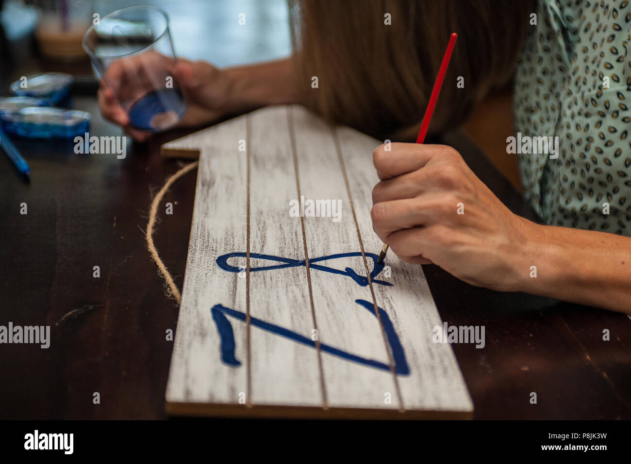 Talented left handed artist painting the lettering for a decorative ...