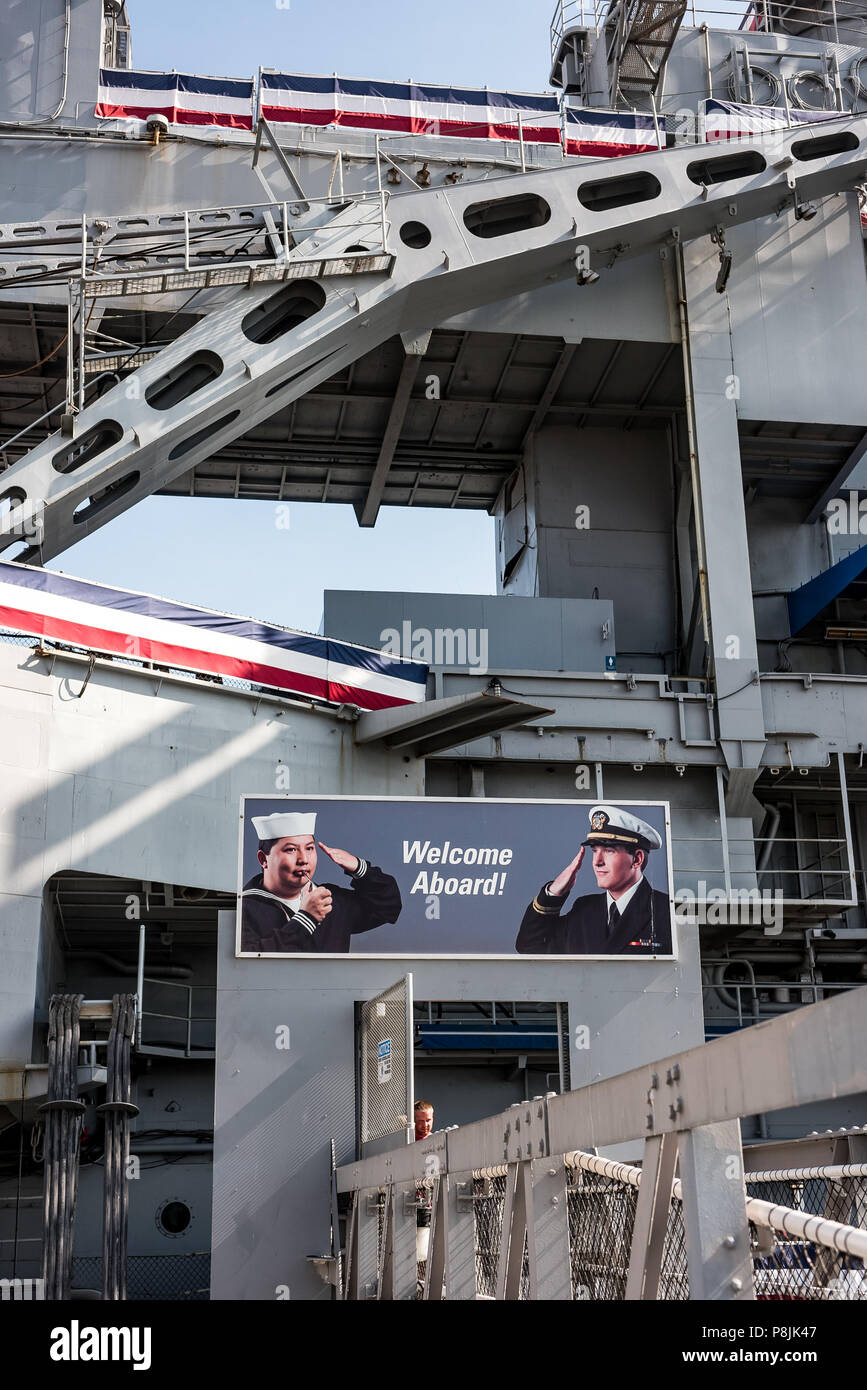 port-side view of USS Midway from the pier showing bunting, signage ...