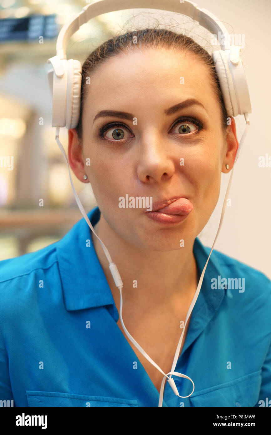 Young attractive girl listening to music on headphones and fooling ...