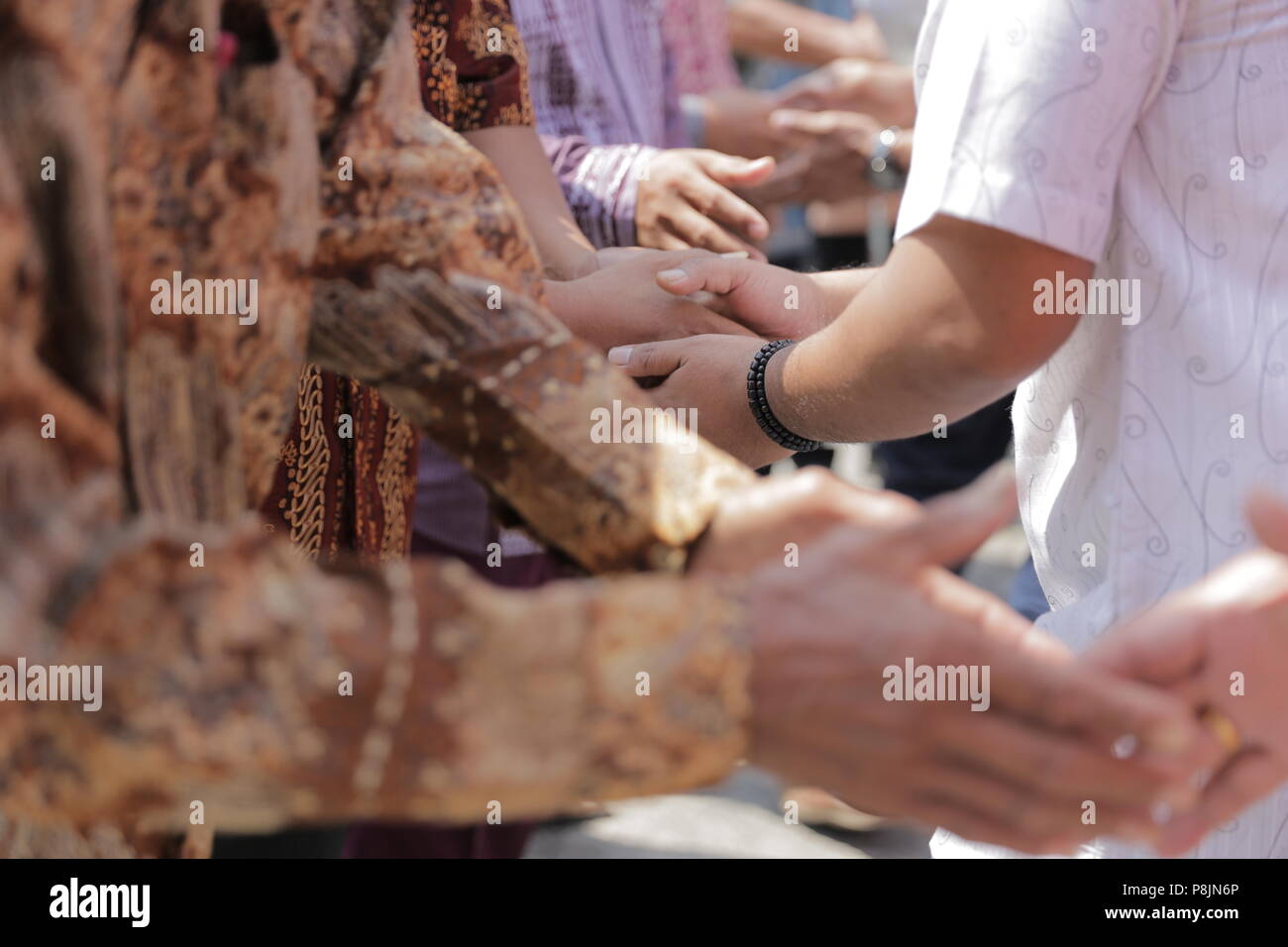 gesture of hand shake hand in traditional shirt during celebration ...
