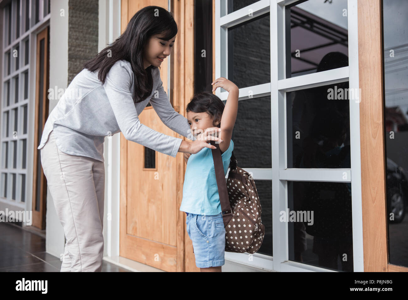 young little girl preparing before going to school with mom Stock Photo ...